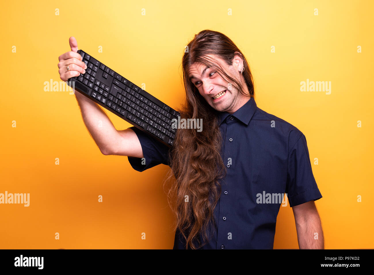 Inspiring male adult holding a keyboard Stock Photo - Alamy