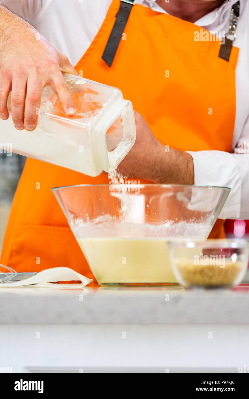 kitchen Preparation: the chef adds flour to the bowl Stock Photo - Alamy