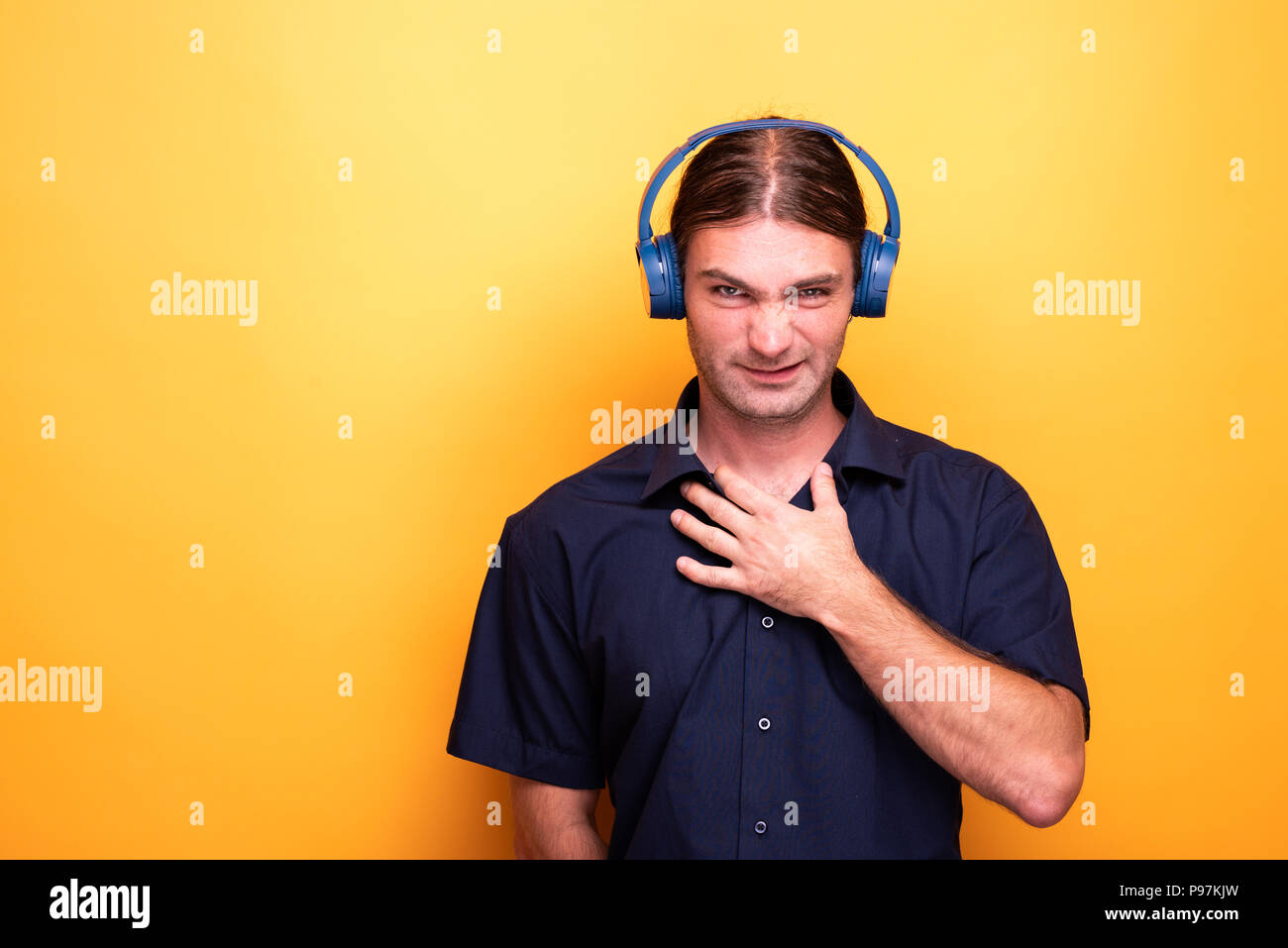 Man wearing headphones resting his hand to its chest Stock Photo - Alamy