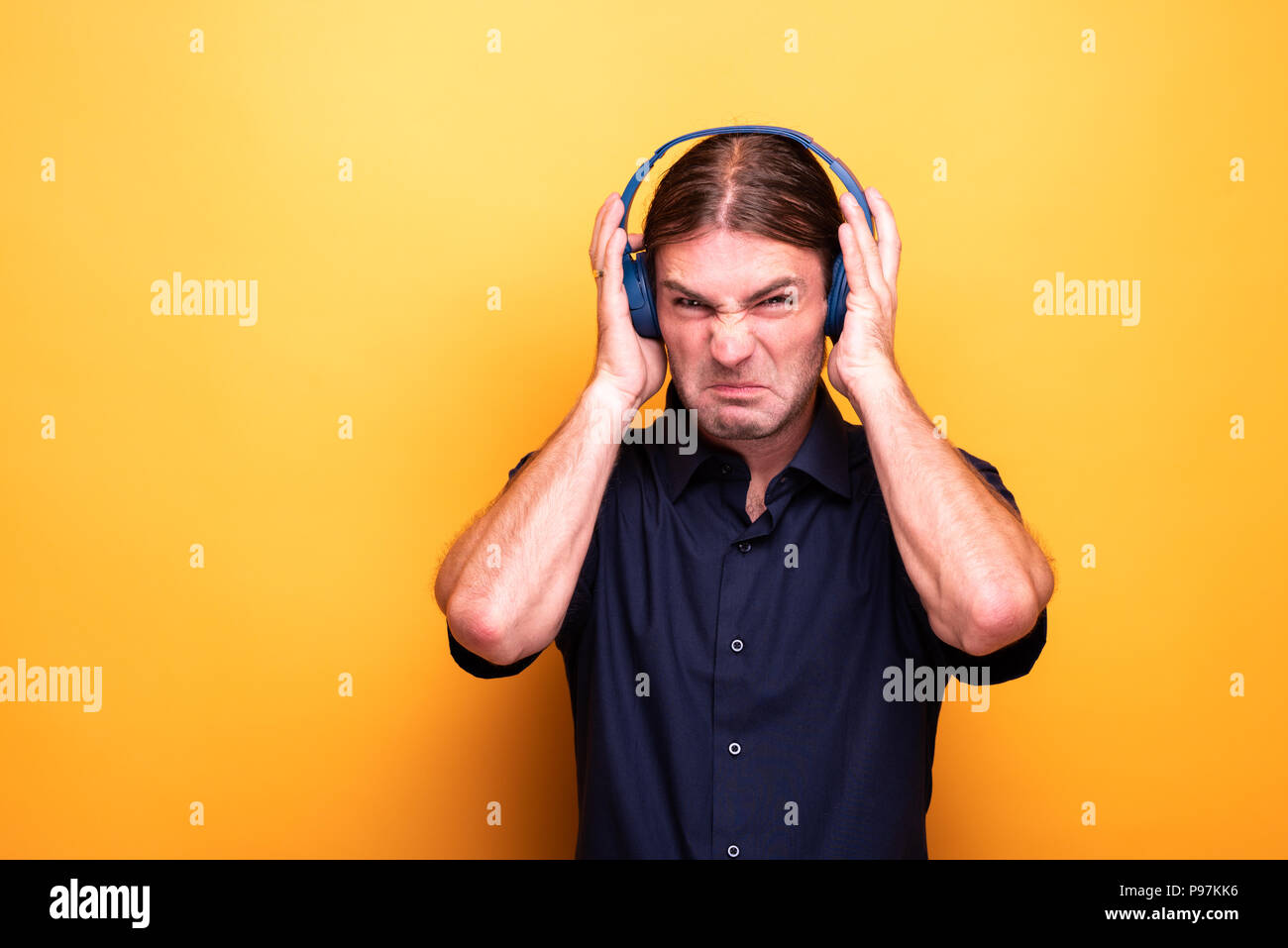 Funny angry man wearing headphones Stock Photo - Alamy