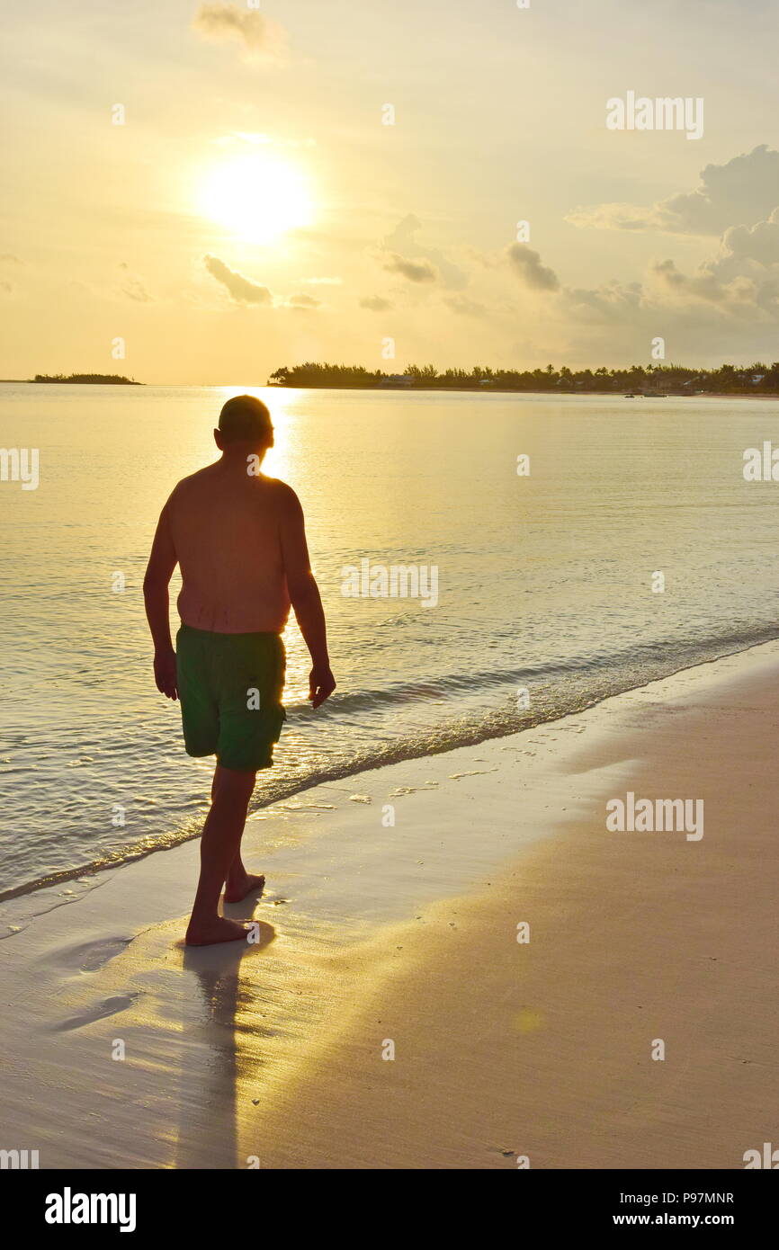 Senior man walking on the Treasure Cay beach early morning on the ...