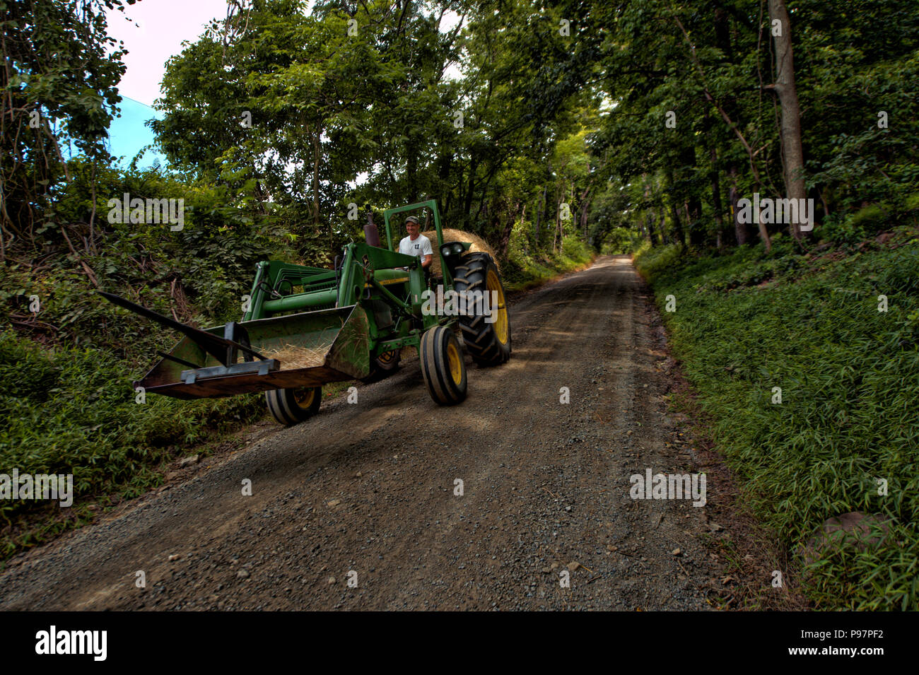 UNITED STATES - July 3, 2017: A hay tractor moves slowly down Western ...