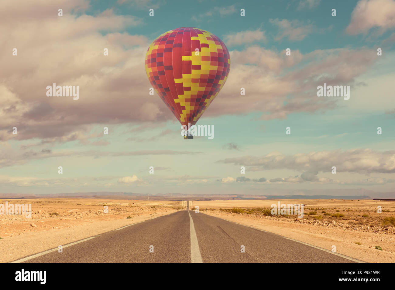 Hot air balloon over desert and road Stock Photo - Alamy
