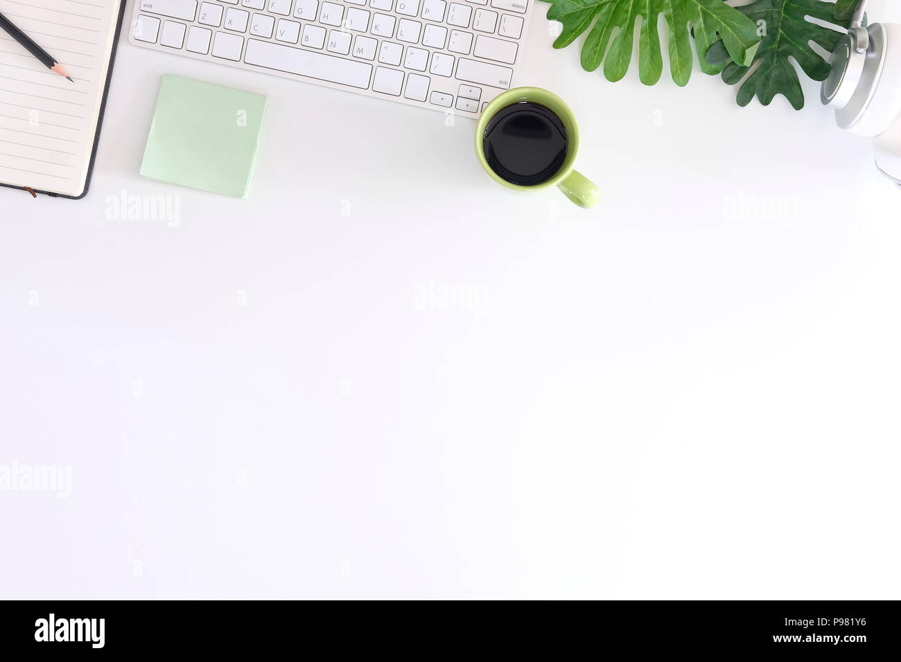 Office desk with computer, pencil, notepaper and headphones with coffee ...