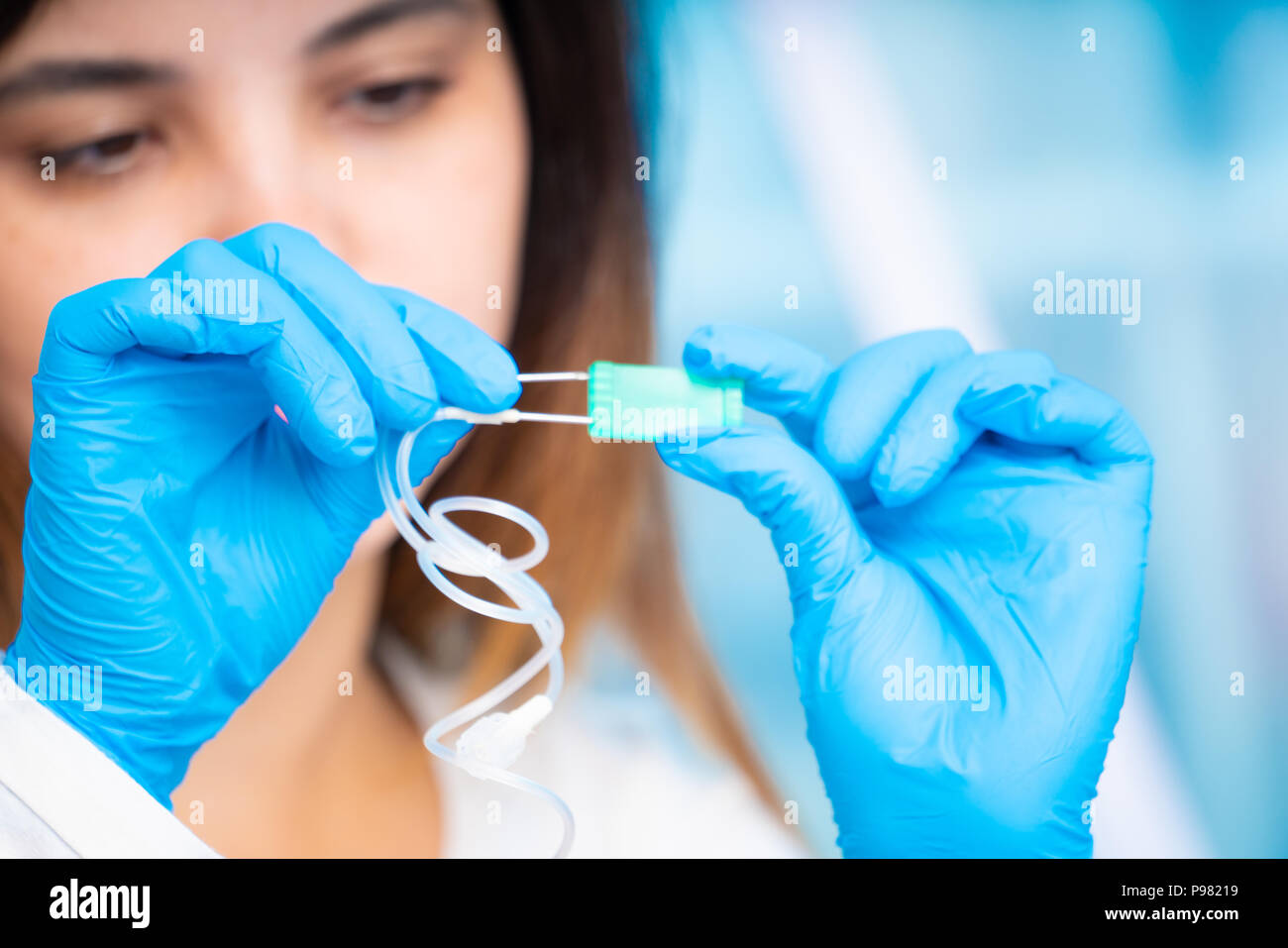 technician girl with microfluidic device LOC in microbiological lab ...