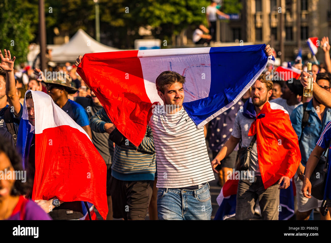 French flags are held high in the air by football fans in Paris after ...