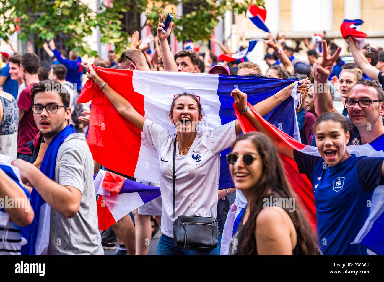 French flags are held high in the air by football fans in Paris after ...