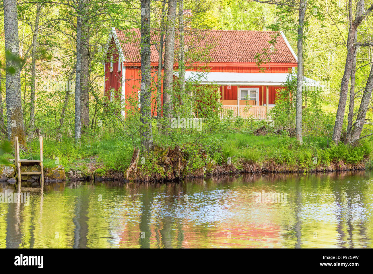 Red cottage by the lake beach Stock Photo - Alamy