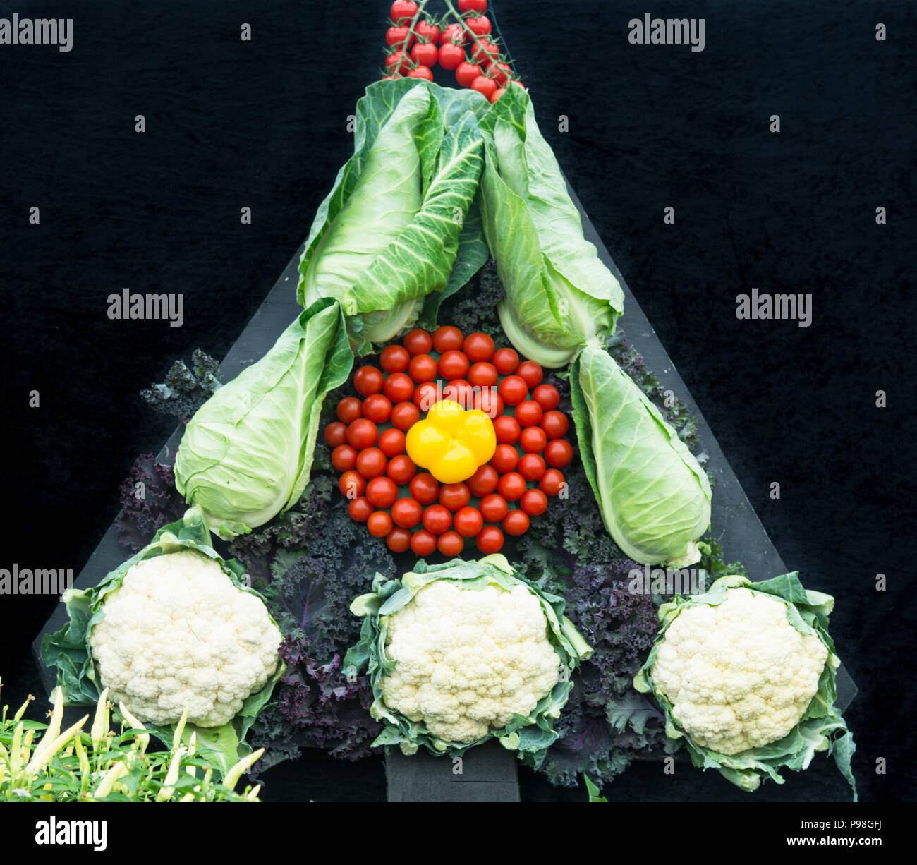 Triangle of vegetables on a black background Stock Photo - Alamy