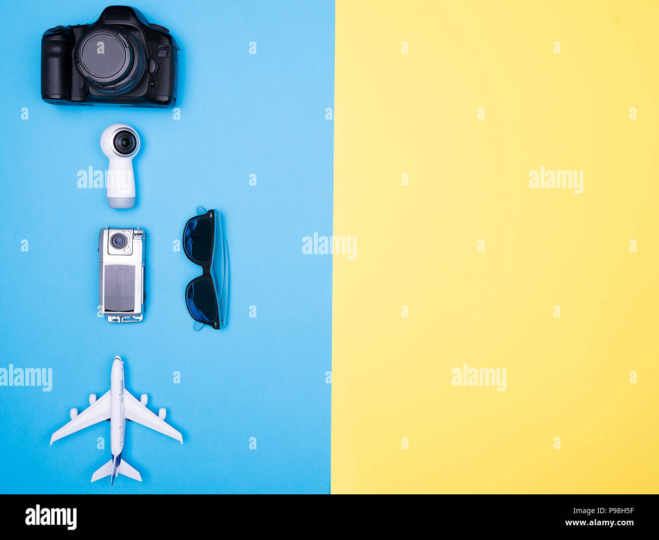 Flat lay top view of plane on yellow background. next to sunglasses and ...