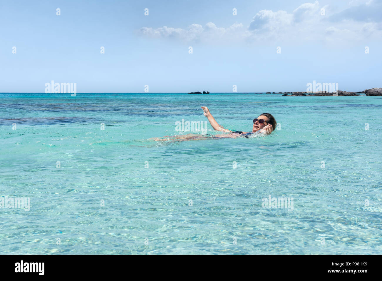 Woman swiming in the sea at Elafonisi beach, in the island of Crete ...