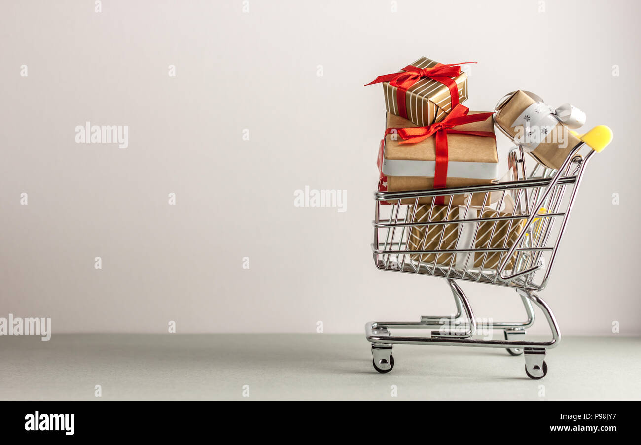 mini shopping cart with boxes with presents Stock Photo - Alamy