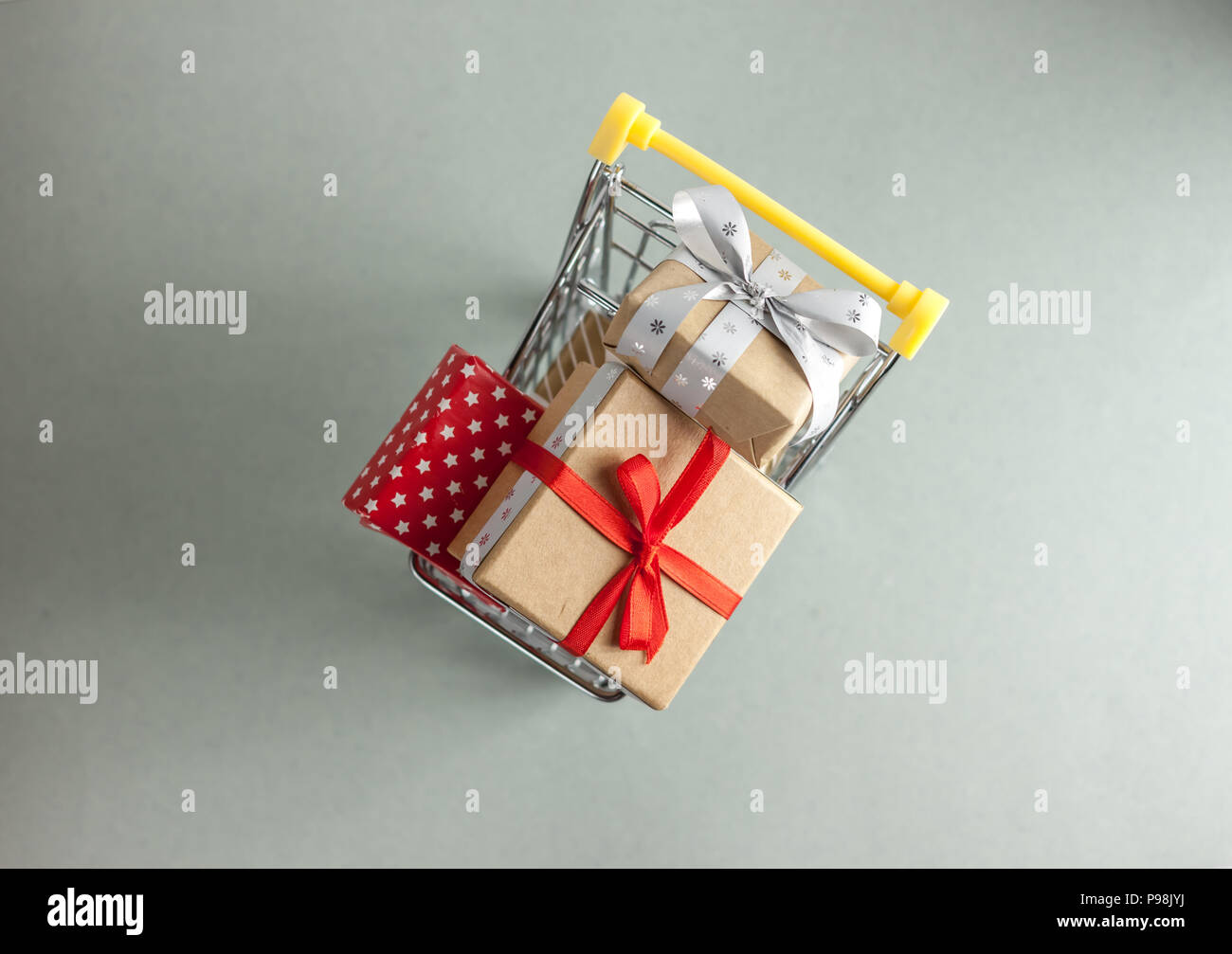 mini shopping cart with boxes with presents Stock Photo - Alamy