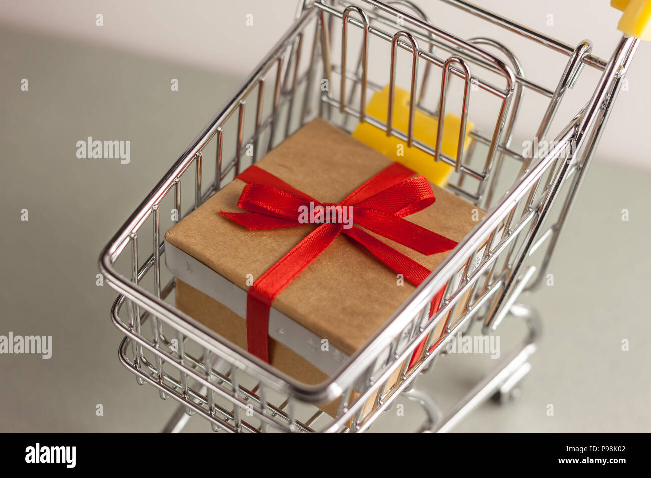 closeup mini shopping cart with gift box Stock Photo - Alamy