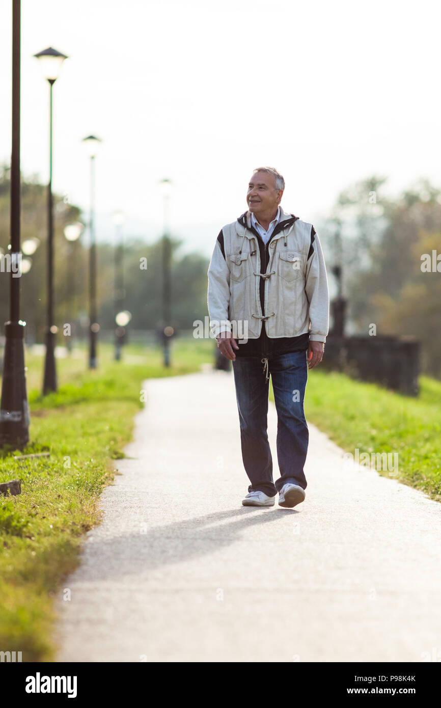 Happy senior man walking on the promenade Stock Photo - Alamy