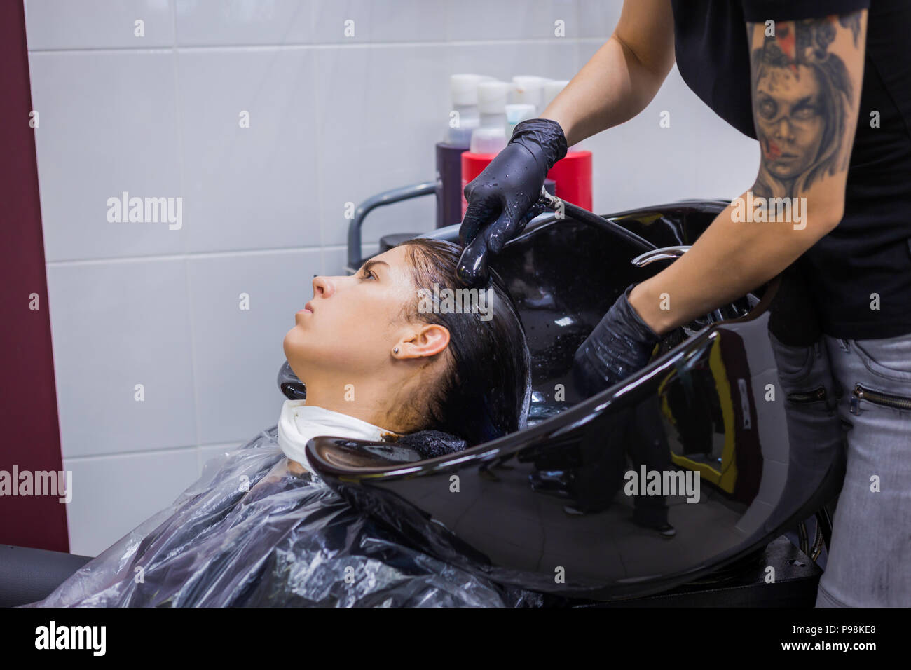Hairdresser washing hair of woman client Stock Photo - Alamy