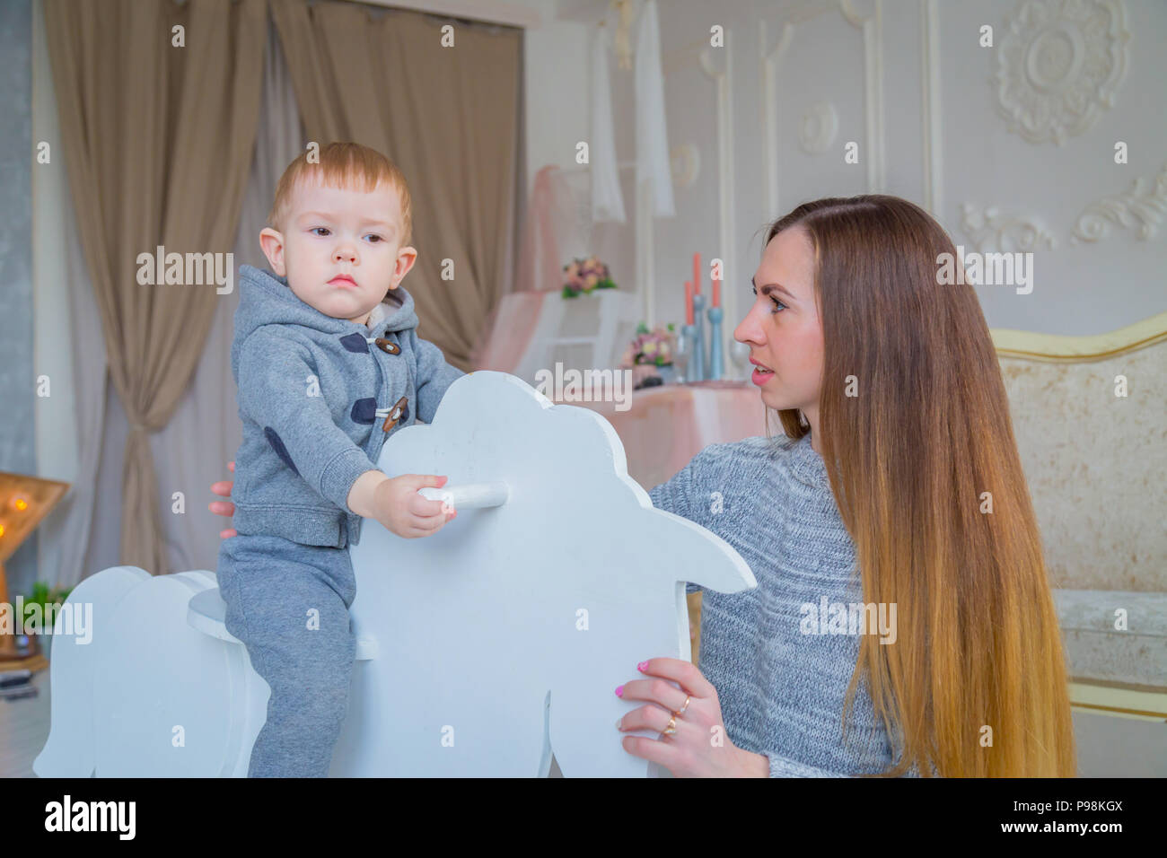 Little boy playing on wooden rocking horse Stock Photo - Alamy