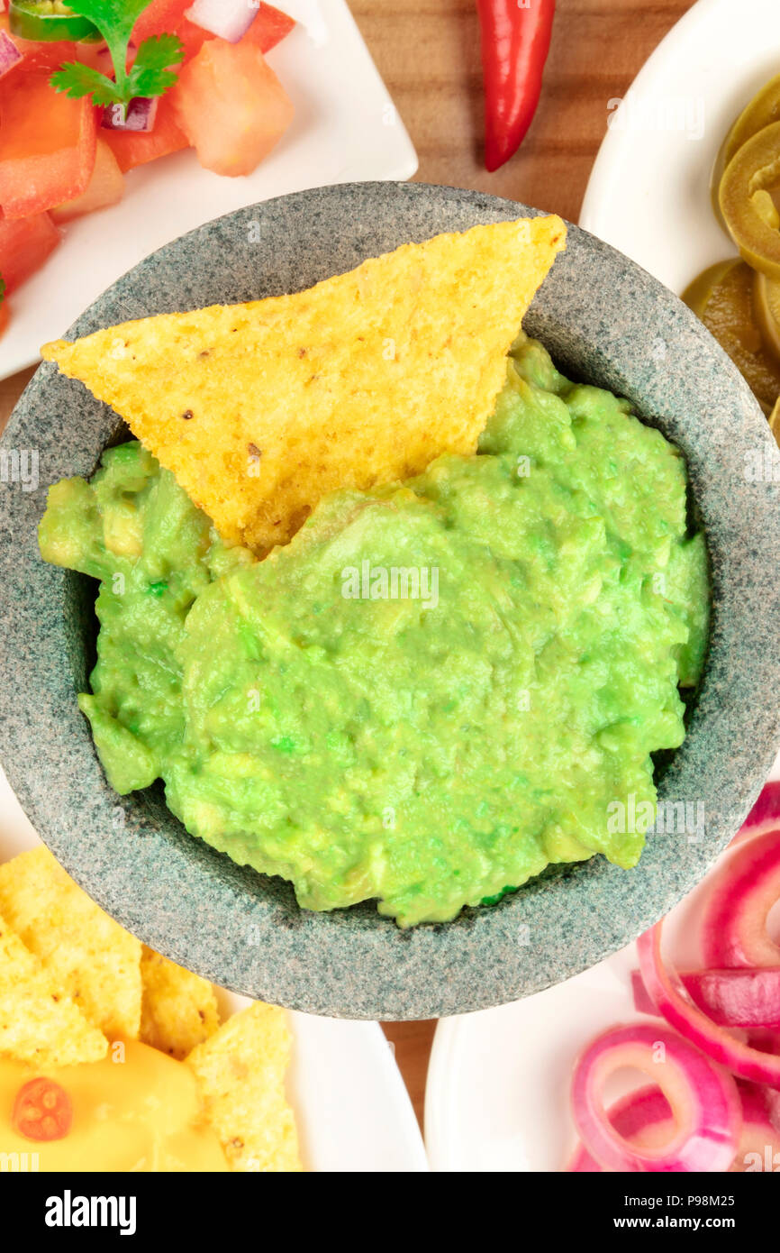 A closeup overhead photo of guacamole sauce in a molcajete, traditional ...