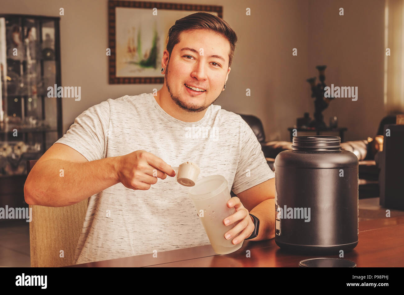 Man going to pour a portion of whey protein at the blending cup. Post ...