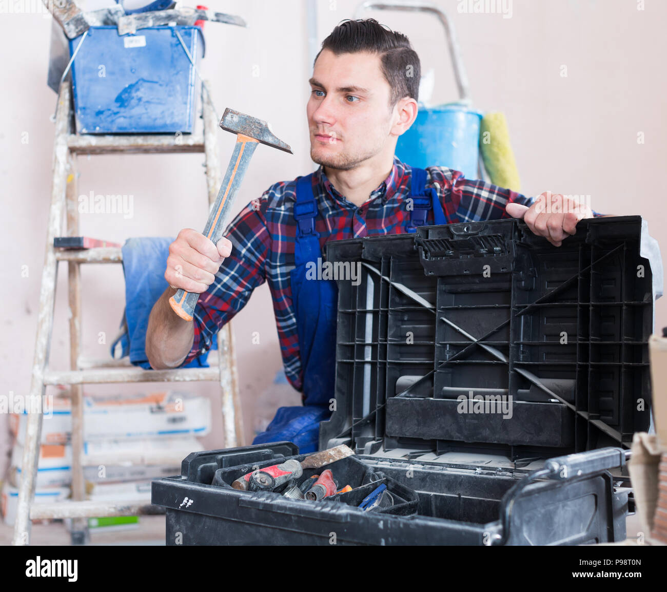 Worker repairing room and looking for necessary tool in toolbox Stock ...