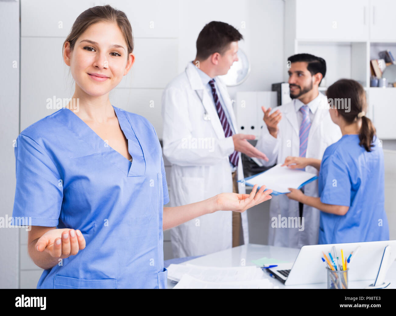 Female doctor making welcome gesture, politely inviting patient in ...