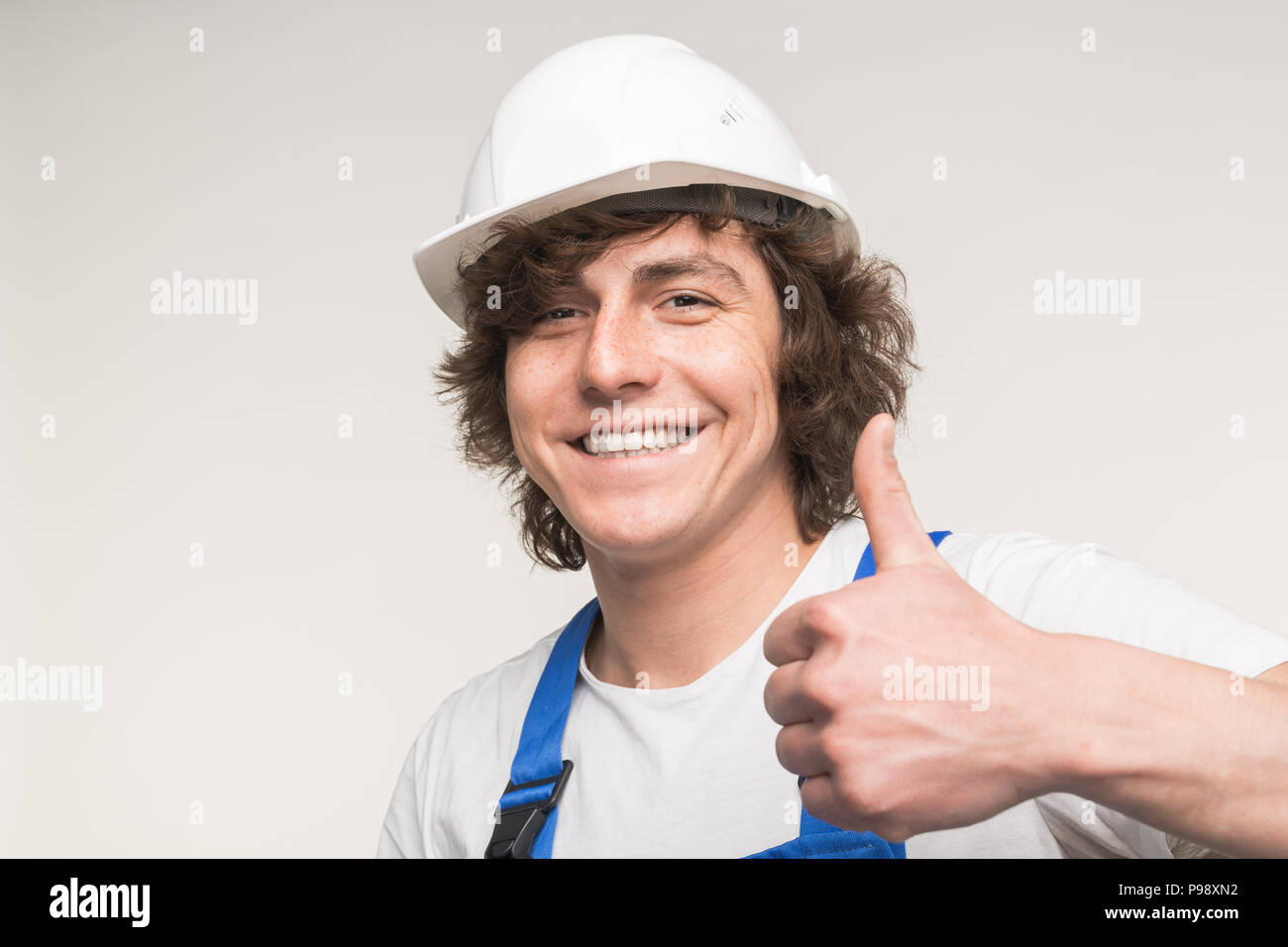 Happy builder man laughing and making thumbs up at camera Stock Photo ...