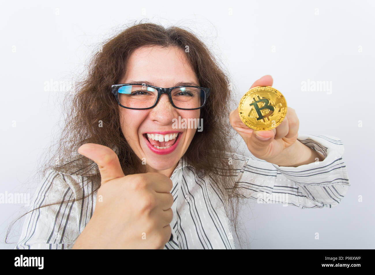 Funny woman holding golden bitcoin and showing thumbs up - successful ...