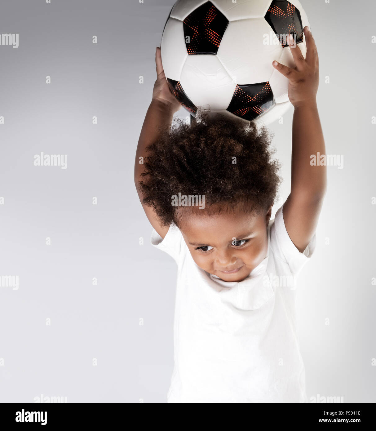 Cute little goalkeeper with soccer ball in hands isolated on clear ...