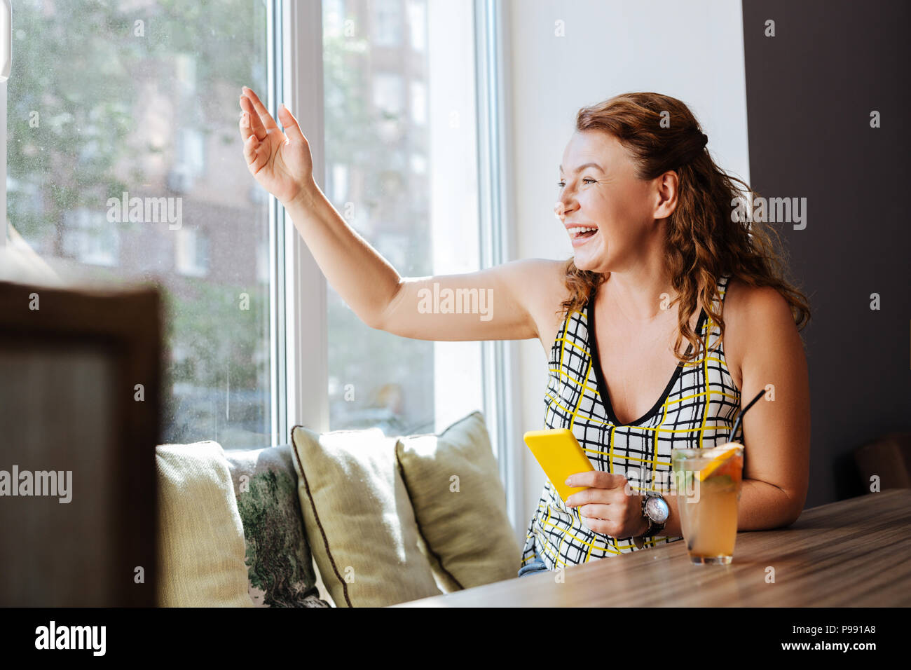 Smiling beautiful mother waving her daughter through window Stock Photo ...