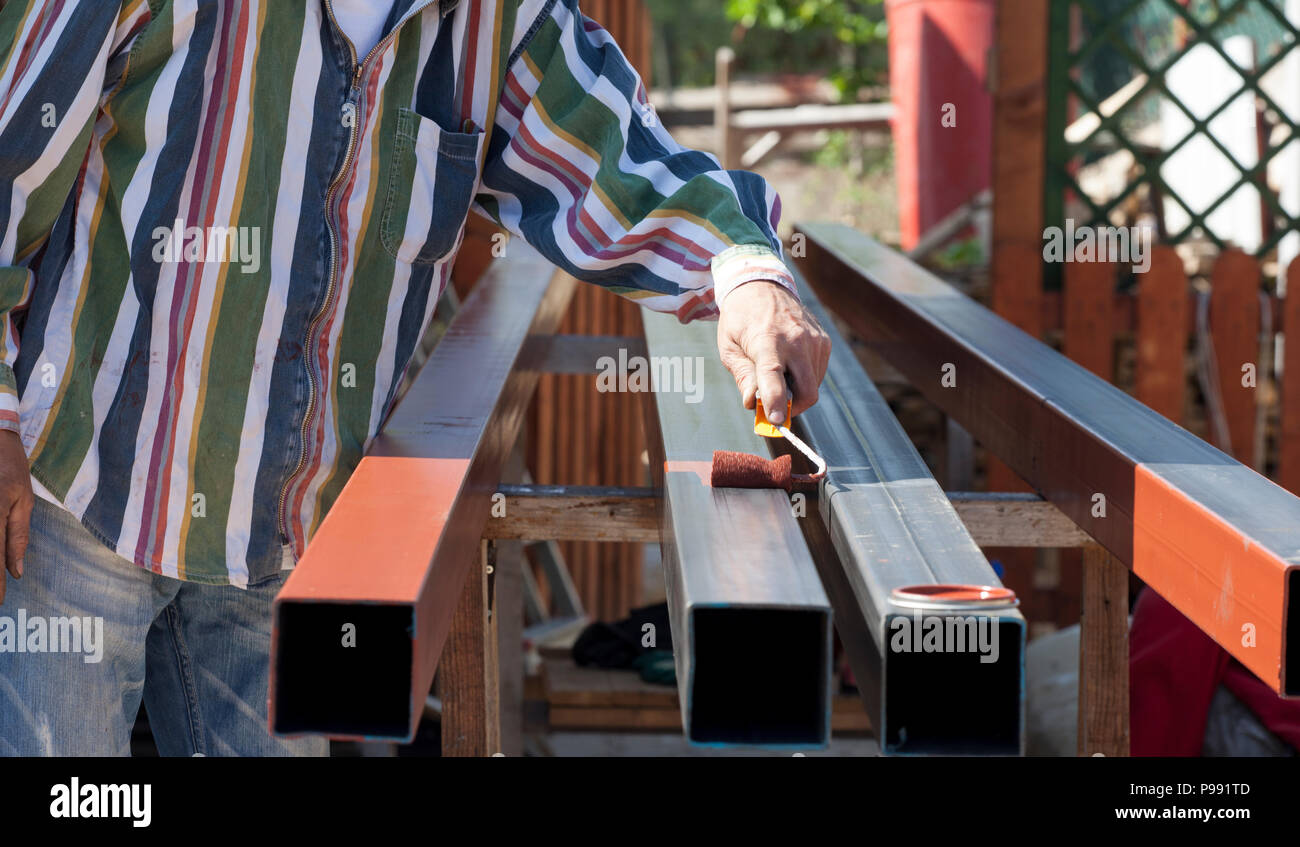 Painting of metal pipe using a roller with the basic paint Stock Photo ...
