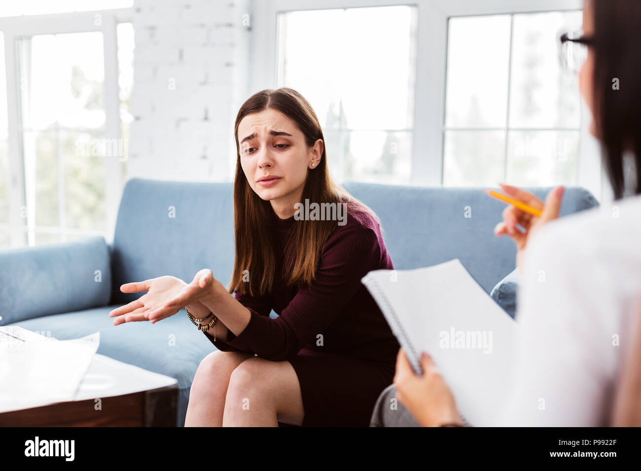 Emotional woman feeling sad and talking about unfair situation Stock ...