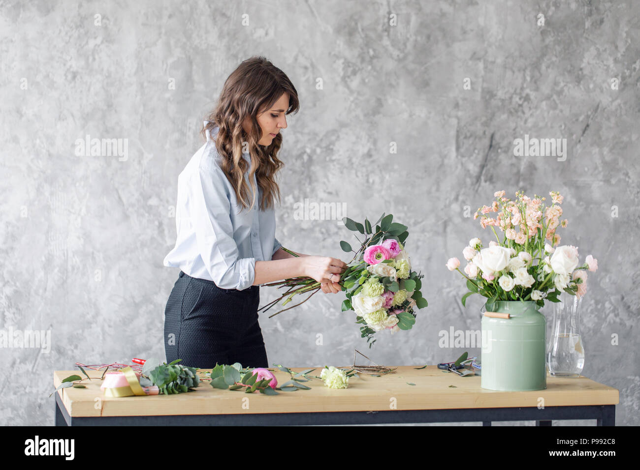 Woman florist creating beautiful bouquet in flower shop. Working in ...