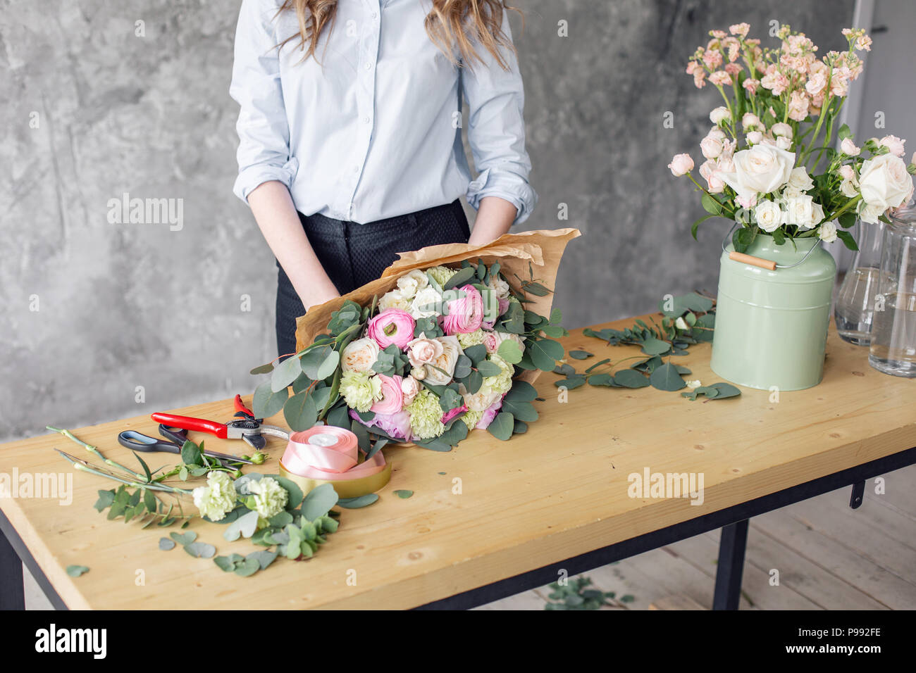 Woman florist creating beautiful bouquet in flower shop. Working in ...