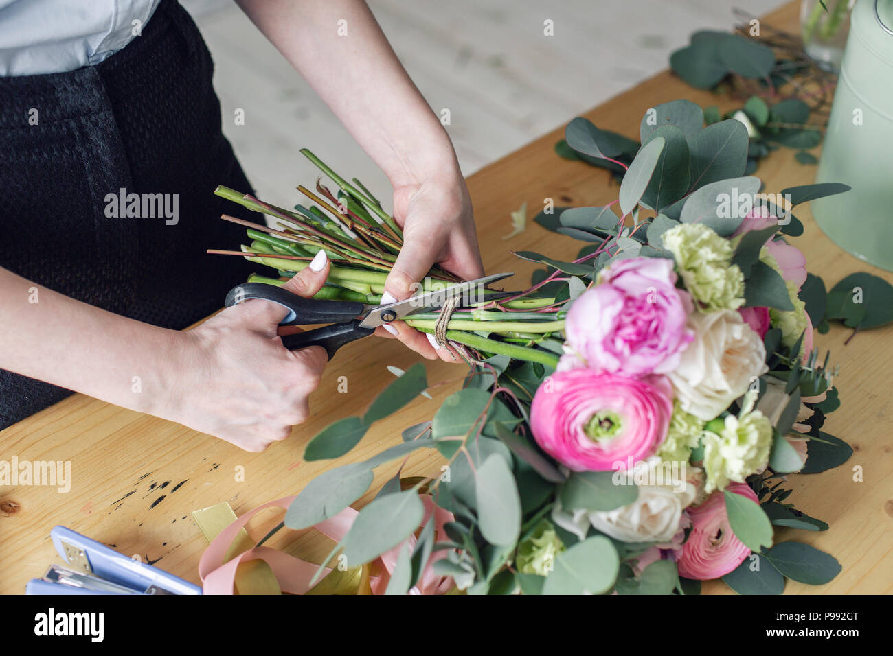 Woman florist creating beautiful bouquet in flower shop. Working in ...