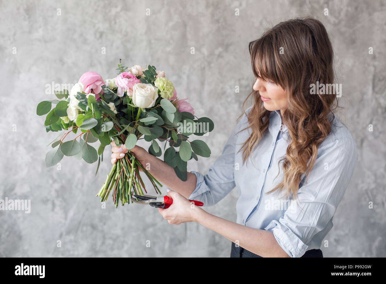 Woman florist creating beautiful bouquet in flower shop. Working in ...