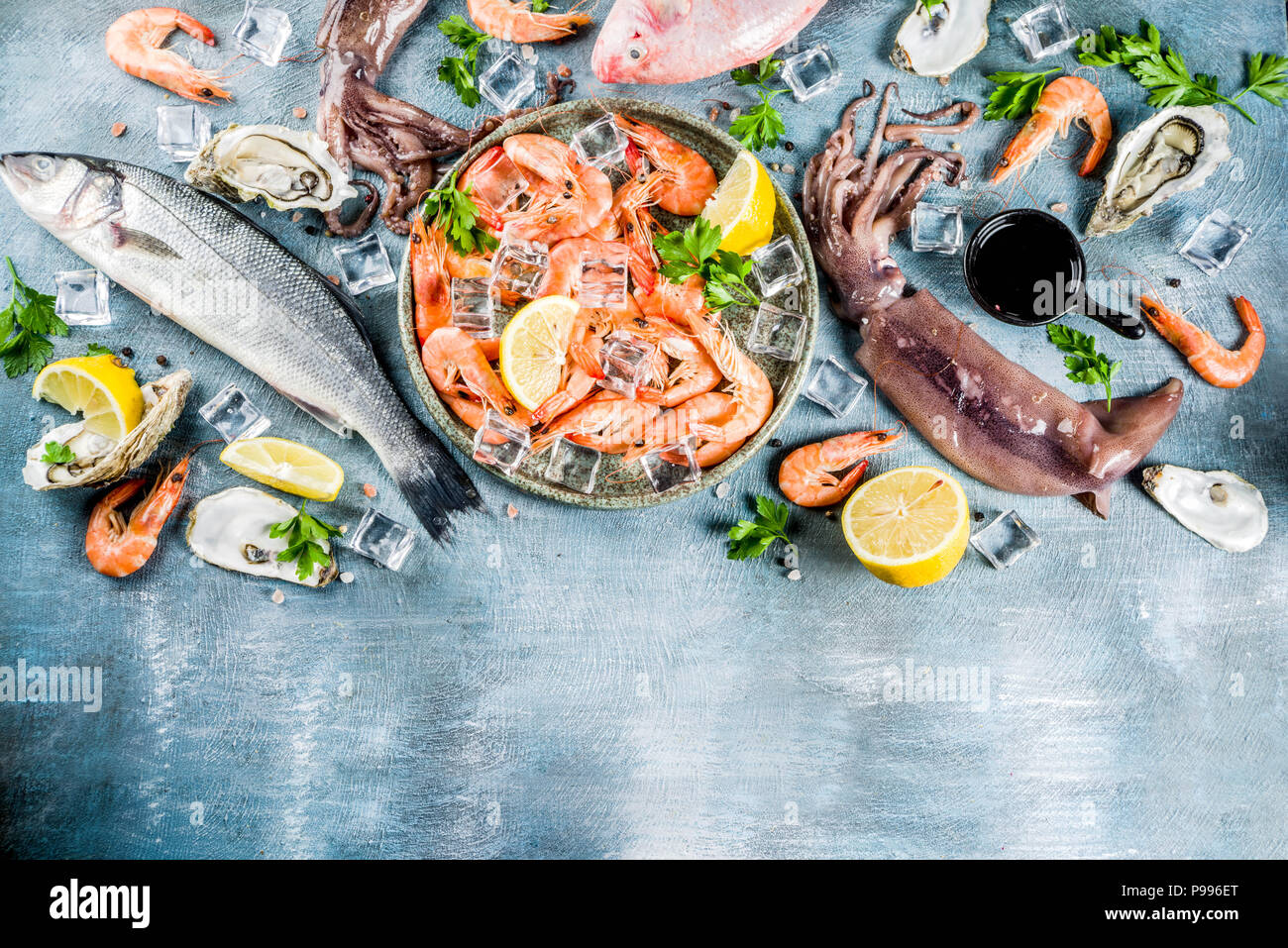 Fresh raw seafood squid shrimp oyster mussels fish with spices of herbs ...