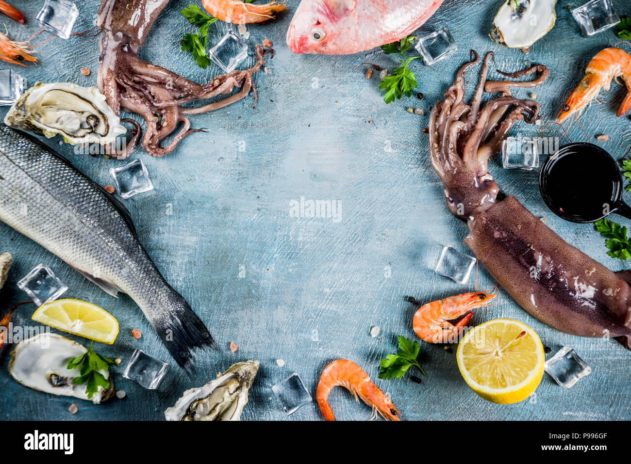 Fresh raw seafood squid shrimp oyster mussels fish with spices of herbs ...