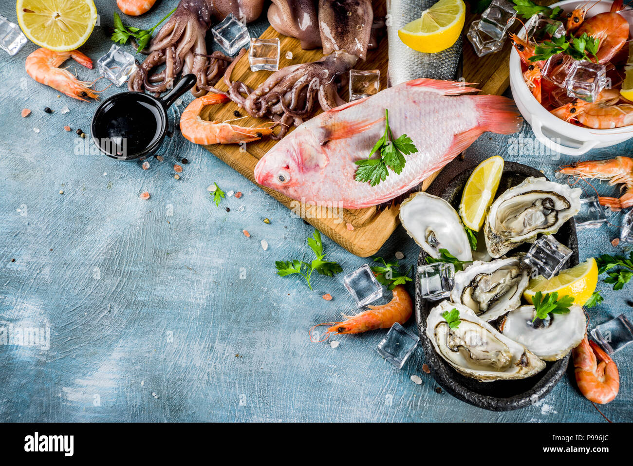 Fresh raw seafood squid shrimp oyster mussels fish with spices of herbs ...