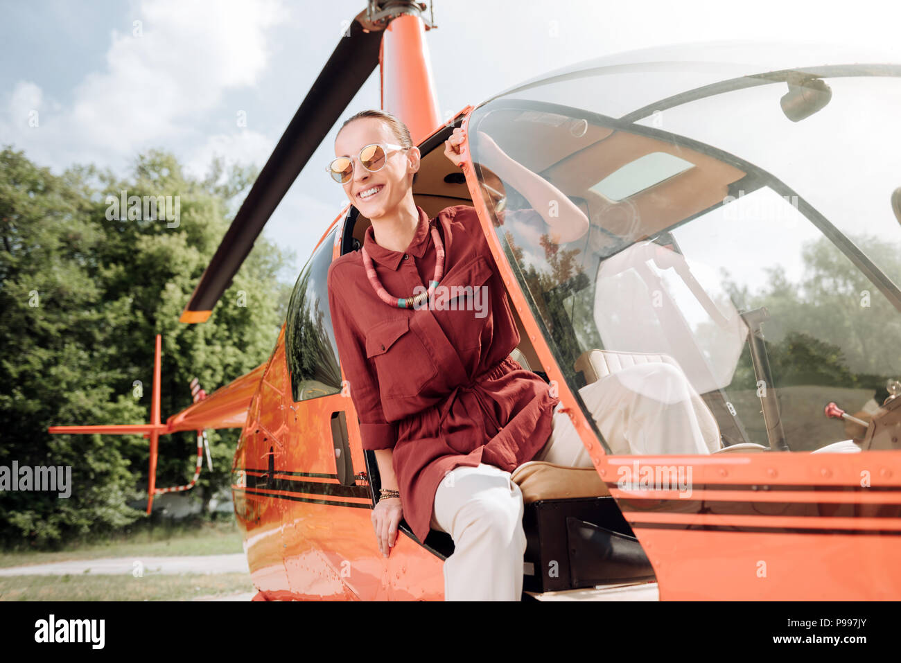 Adorable cheerful woman getting off helicopter Stock Photo - Alamy