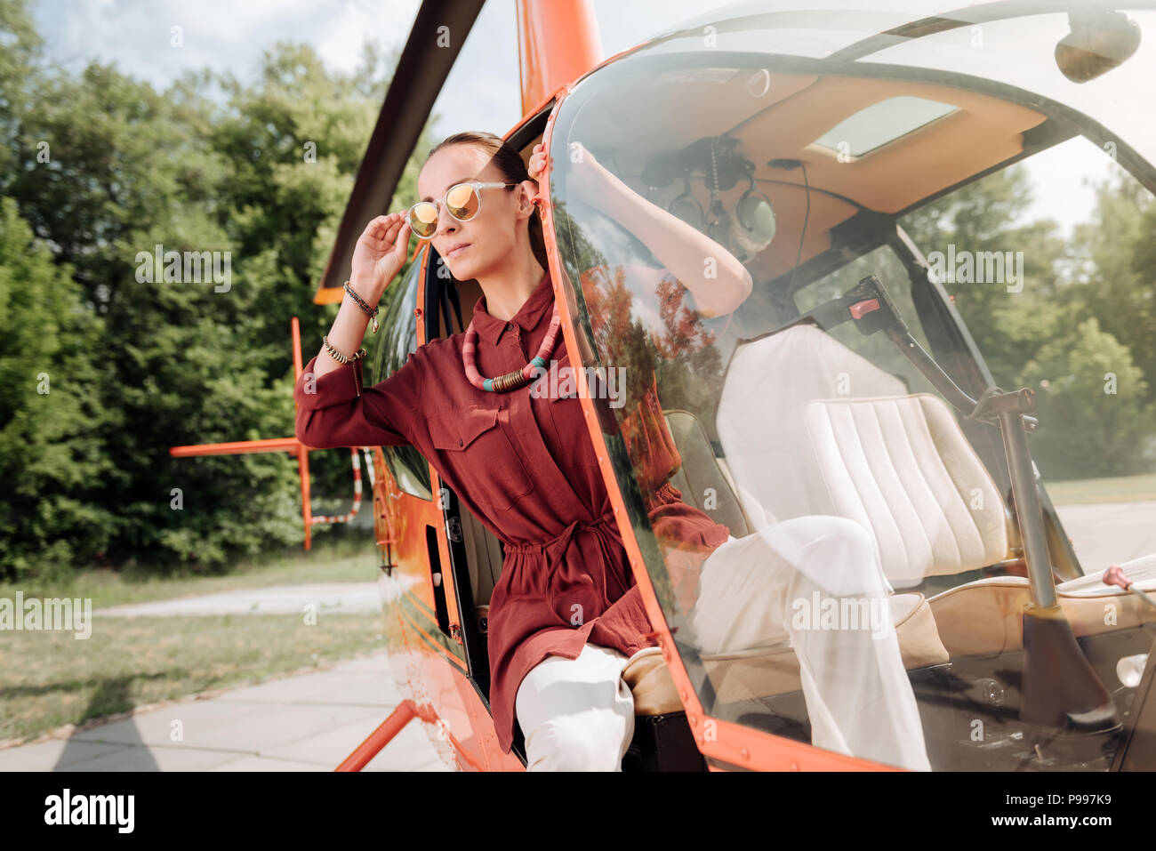 Focused serious woman getting in helicopter Stock Photo - Alamy