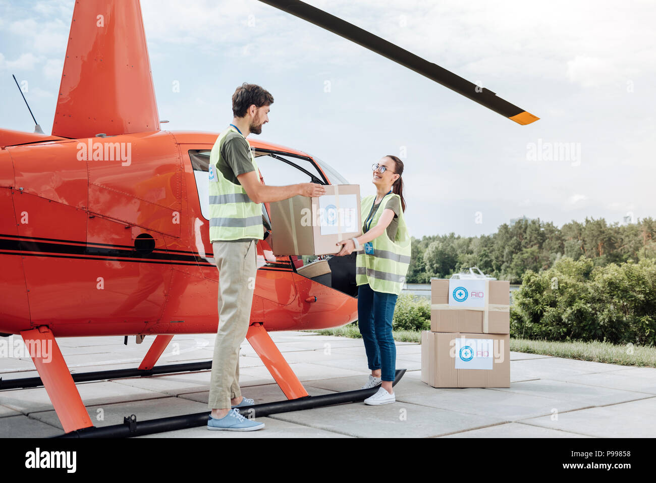 Happy two volunteers helping people Stock Photo - Alamy