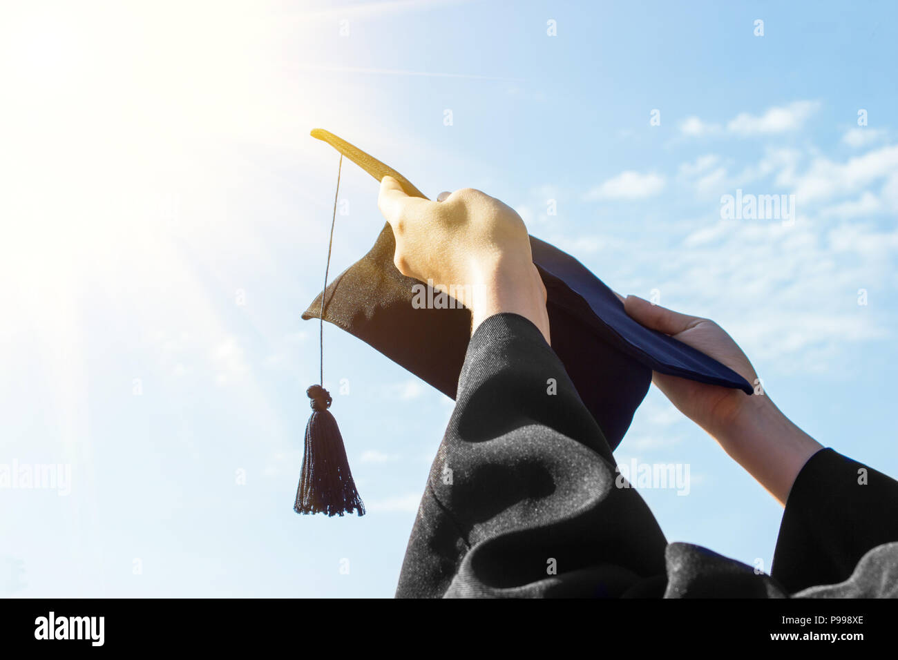 Graduate celebrating with cap in her hand,feeling so proud and ...