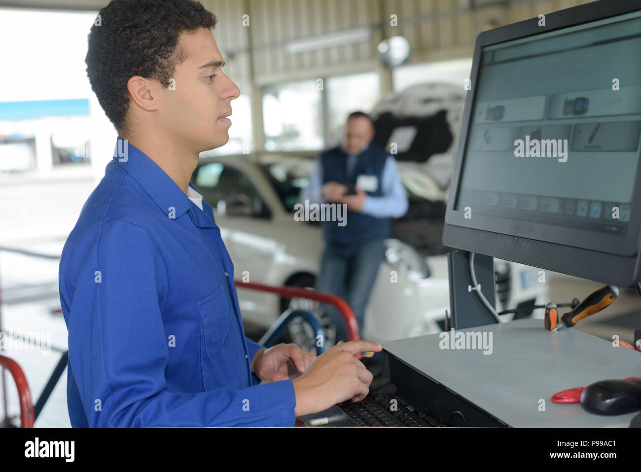 mechanic using computer diagnostics while repairing car Stock Photo - Alamy