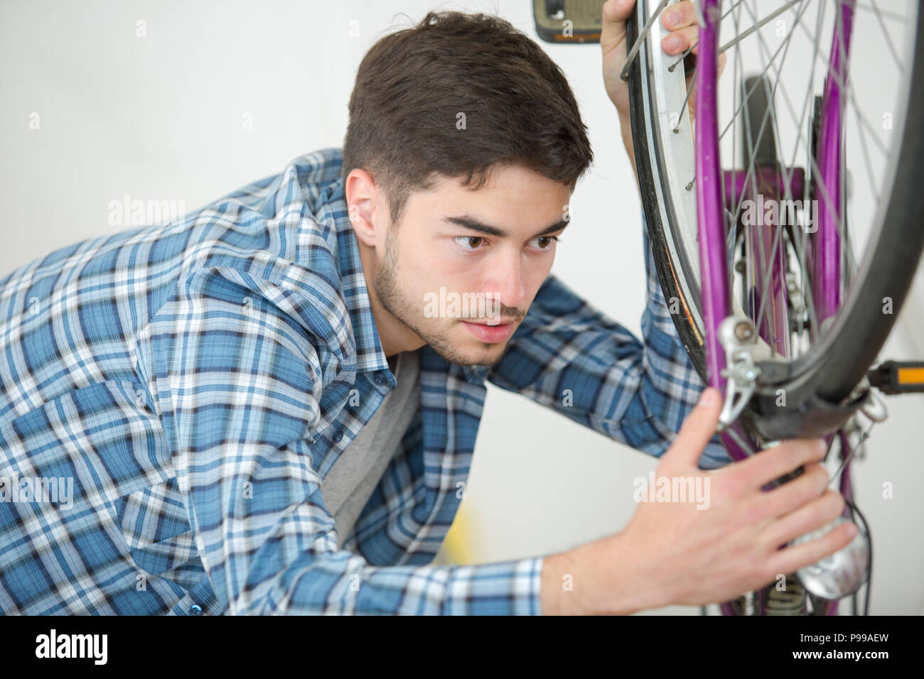 man fixing wheel of bike at home Stock Photo - Alamy