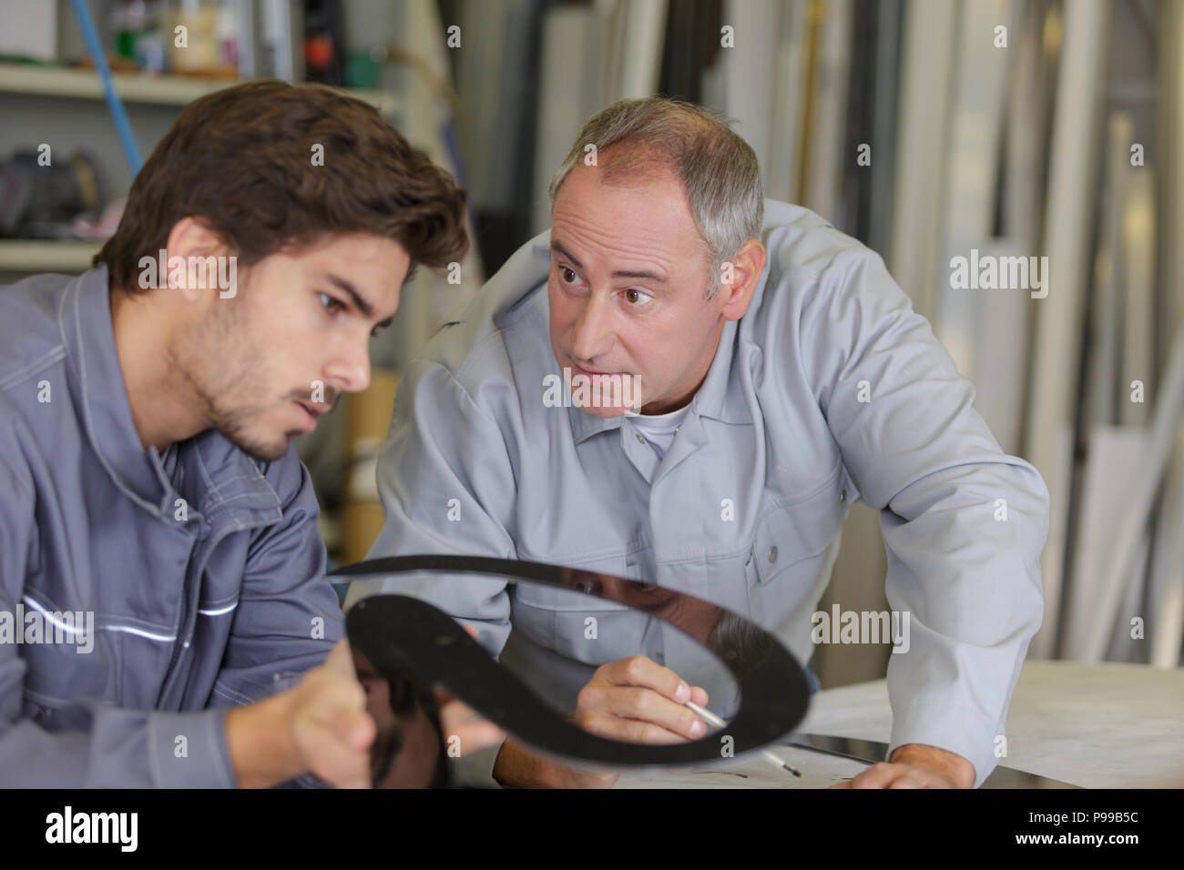 two workmen conferring over paperwork Stock Photo - Alamy