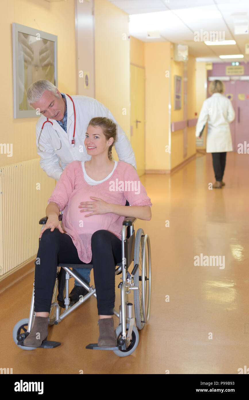 pregnant woman being pushed on the wheelchair Stock Photo - Alamy