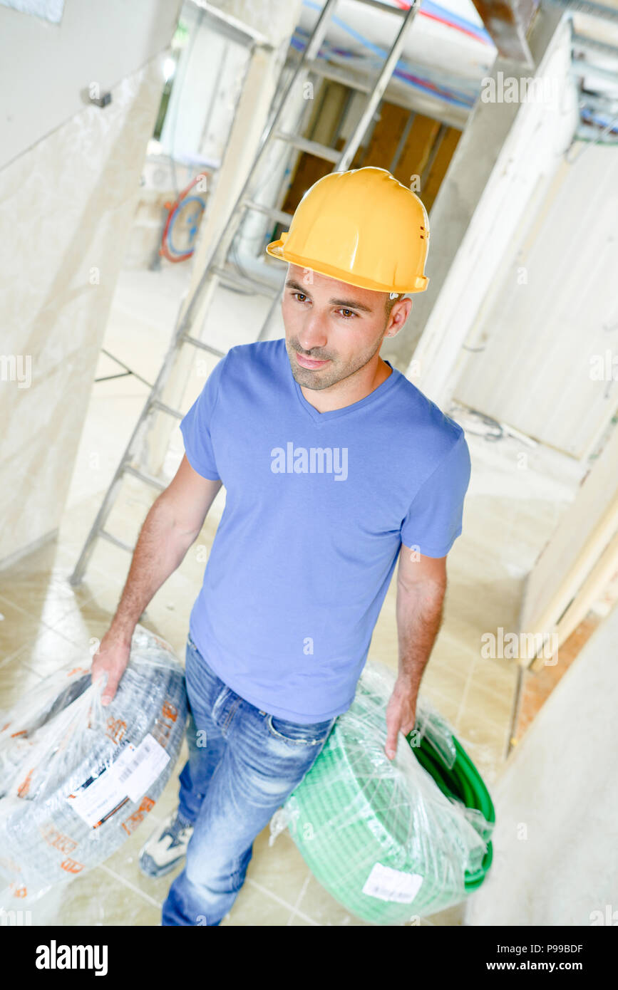 Man carrying spools of electrical cable Stock Photo - Alamy