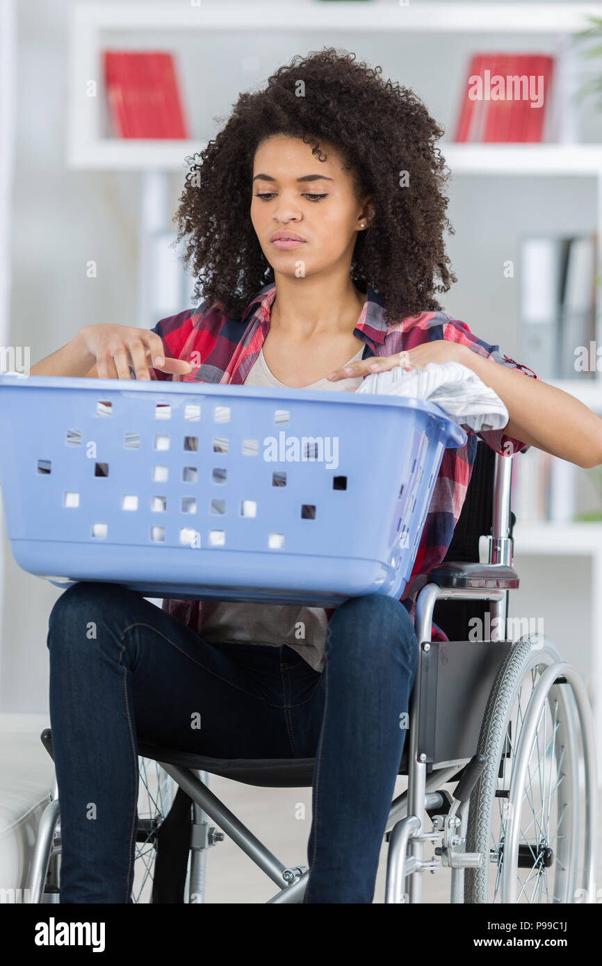 young disabled woman on wheelchair doing laundry Stock Photo - Alamy