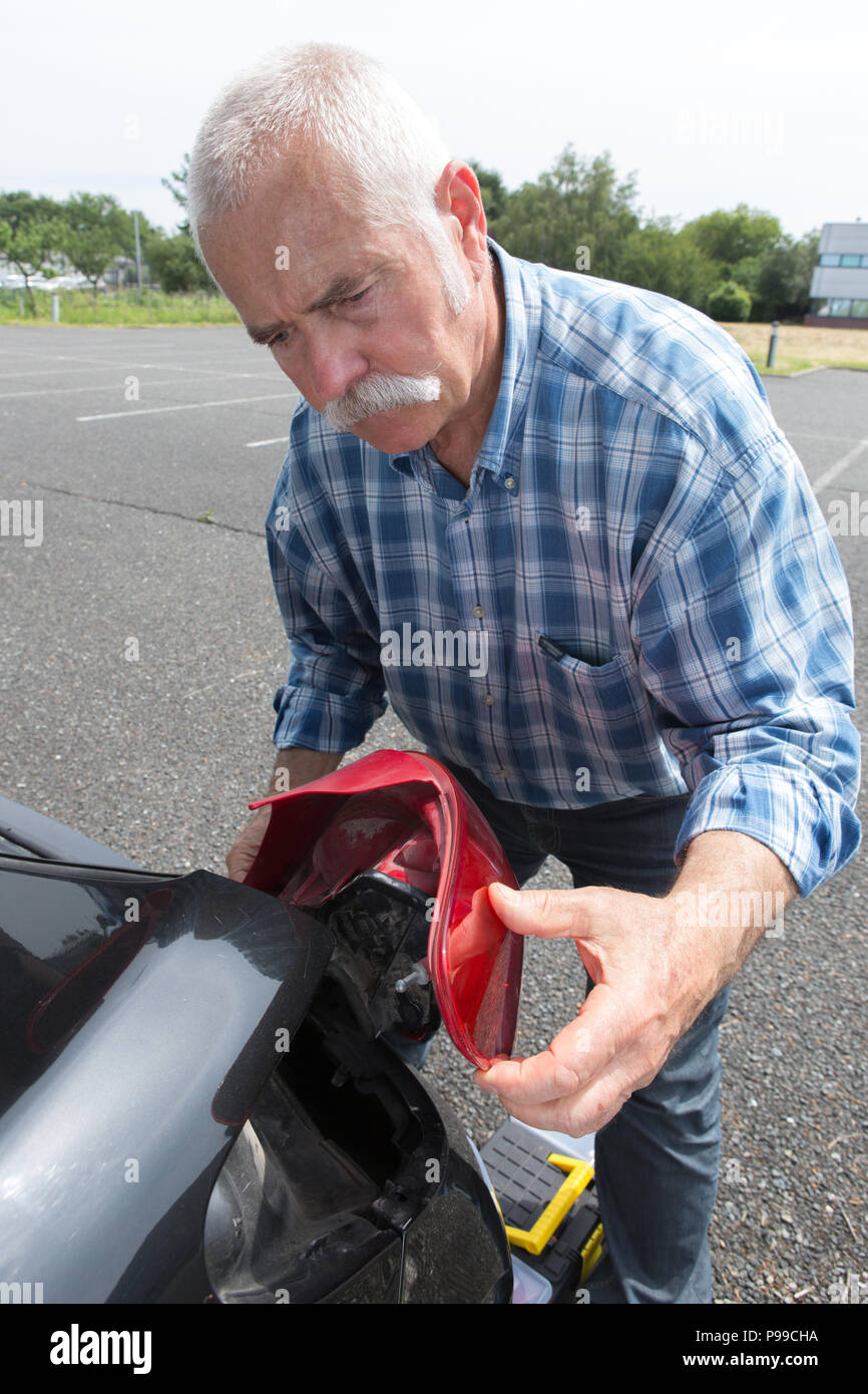 old man installs tail light on the vehicle Stock Photo - Alamy