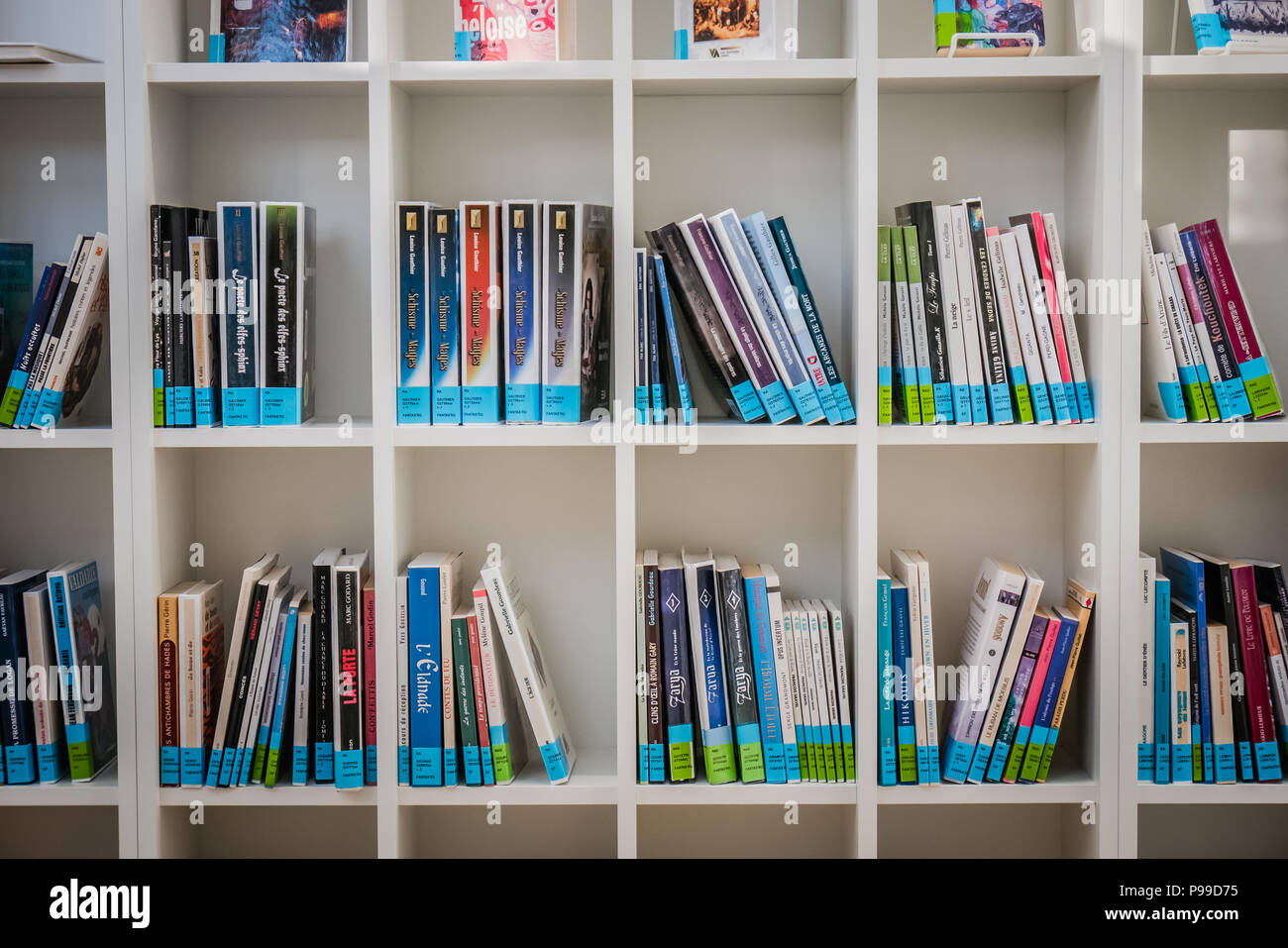 books on small sections of a big white bookshelf Stock Photo - Alamy
